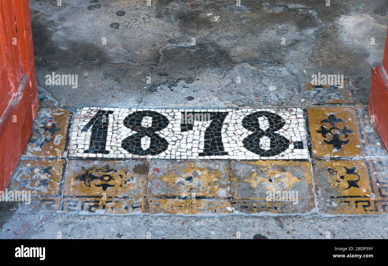 Inscription 1878 on shabby concrete floor by the entrance to an old ...