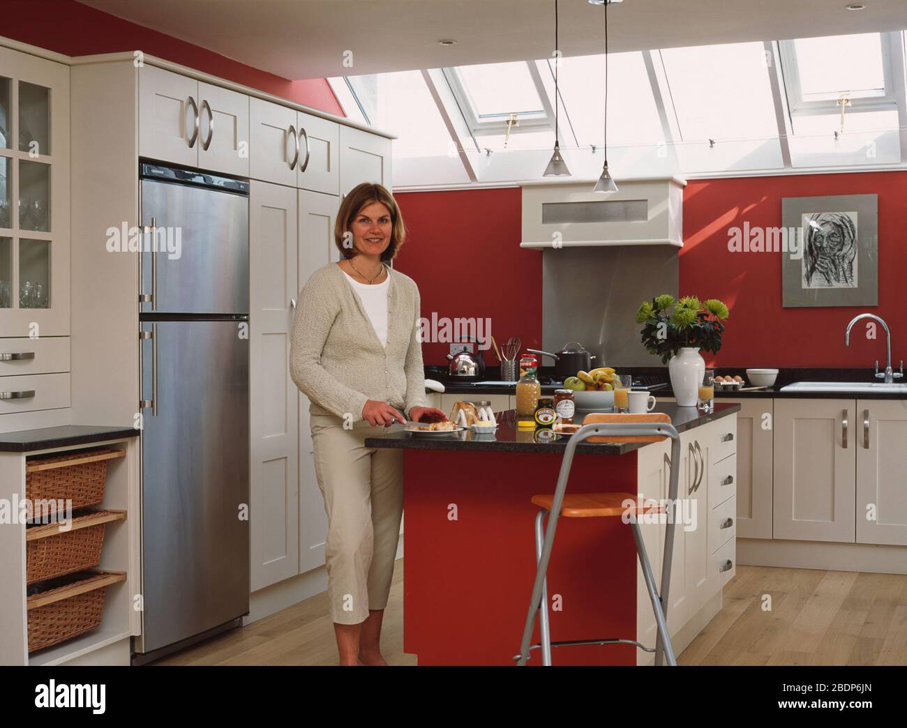 Woman in red kitchen preparing breakfast FOR EDITORIAL USE ONLY ...