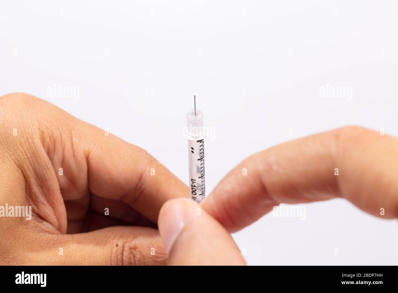 Hand holding an insulin syringe before being used Stock Photo - Alamy