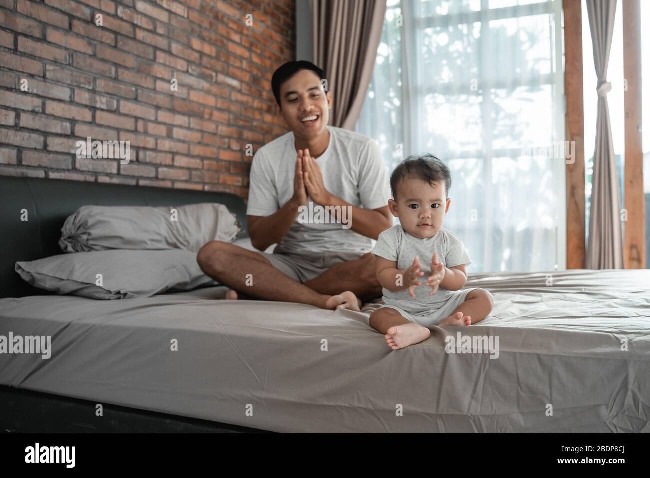 father bonding with baby. man playing with his daughter on the bed ...