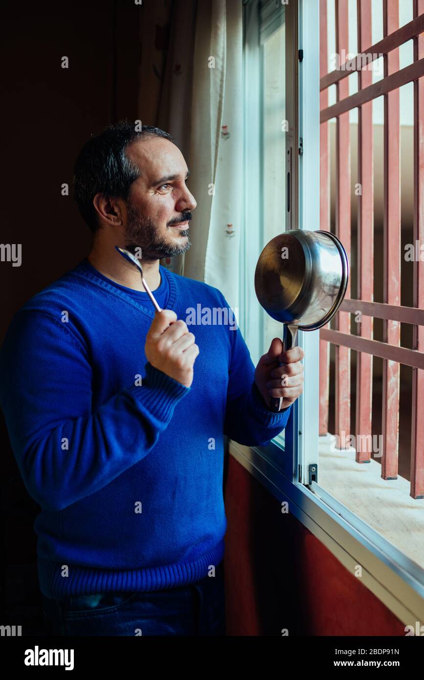man hitting pans during casserole on house Stock Photo - Alamy