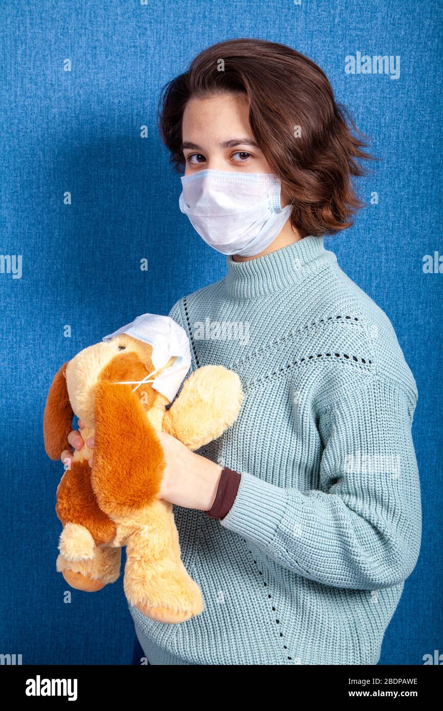 quarantined girl and toy puppy in medical masks COVID-19 pandemic Stock ...