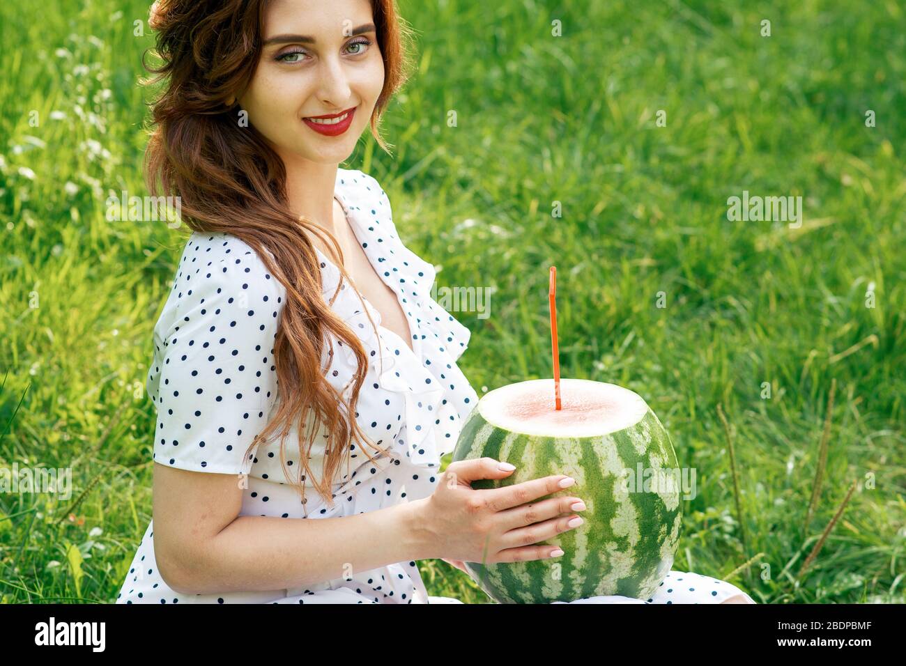 Beautiful young woman with watermelon sits on grass outdoors Stock ...
