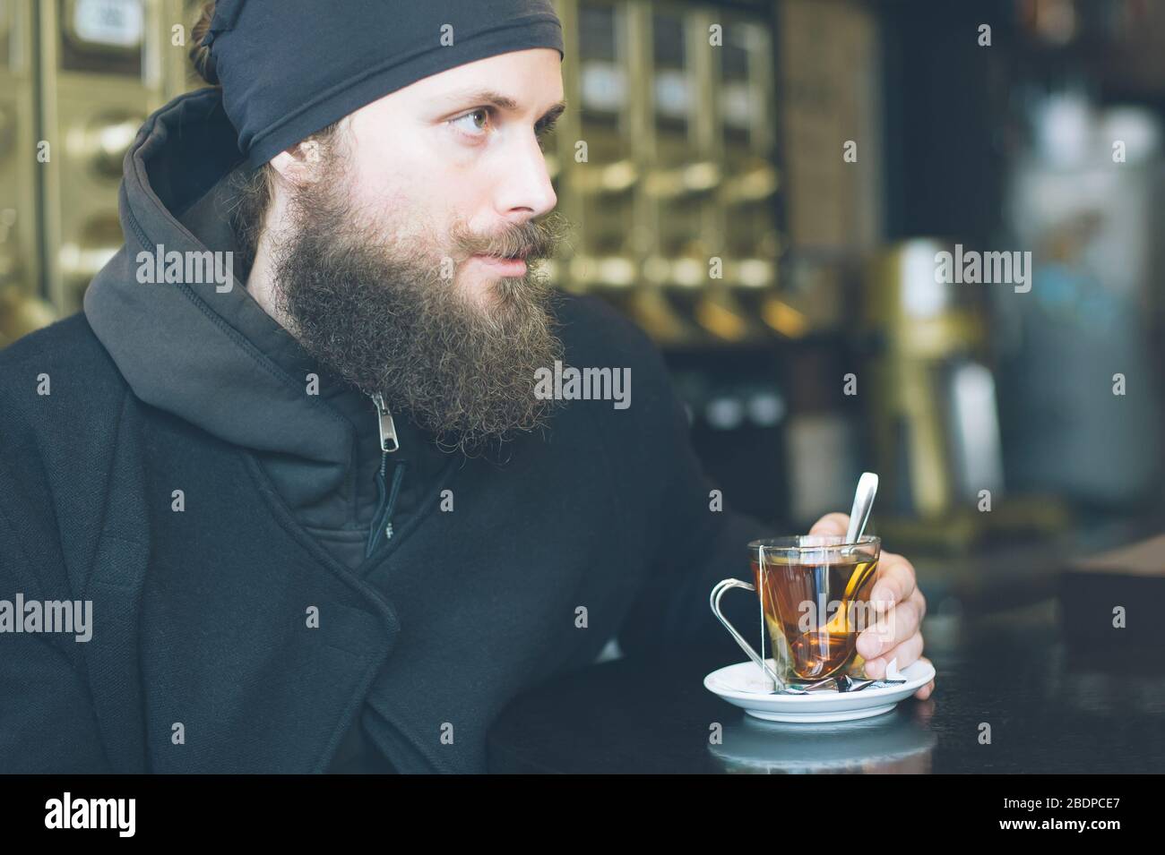 Portrait of handsome young man enjoying tea in a restaurant Stock Photo ...
