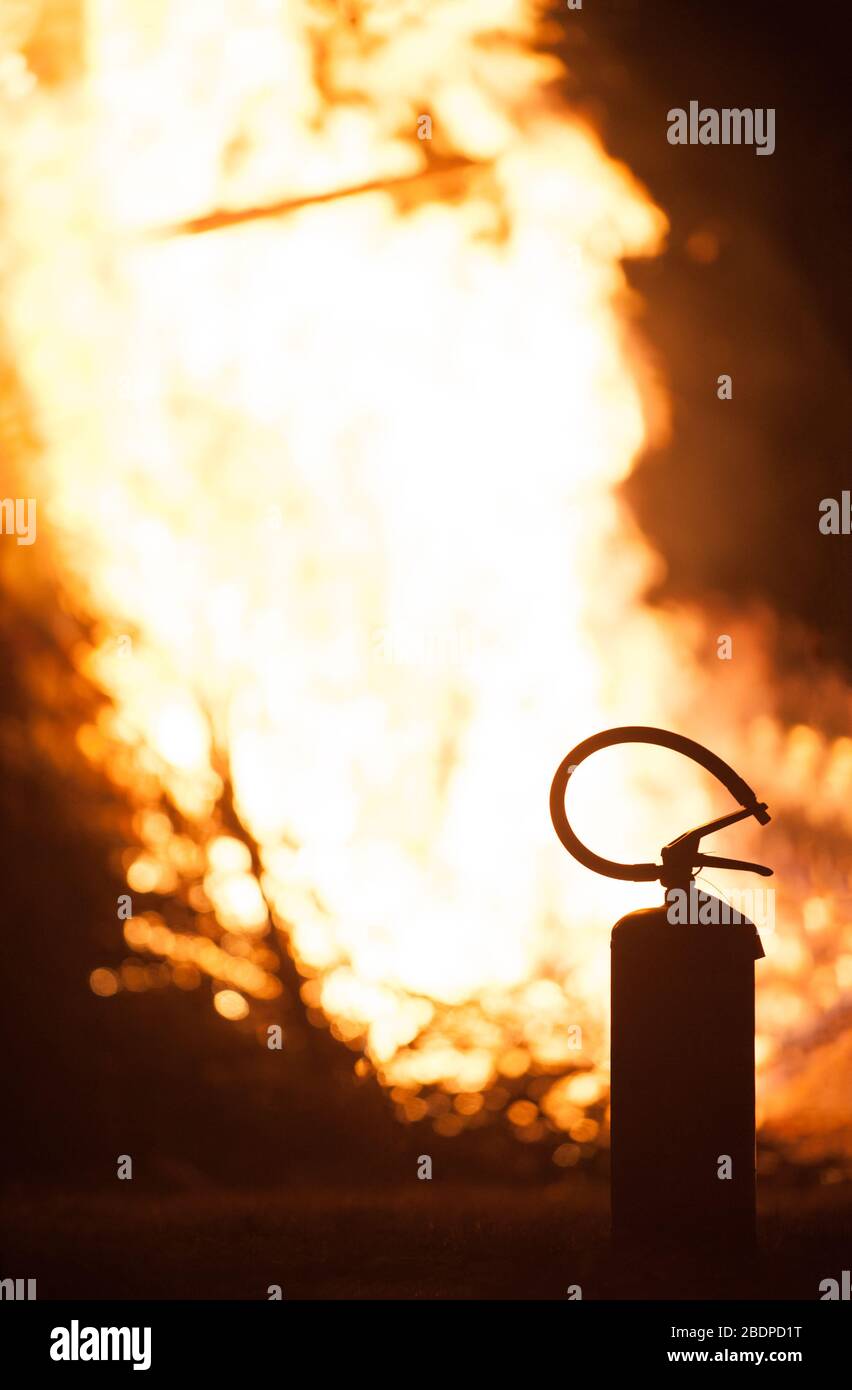 a fire flares up in the background, a fire extinguisher in the ...