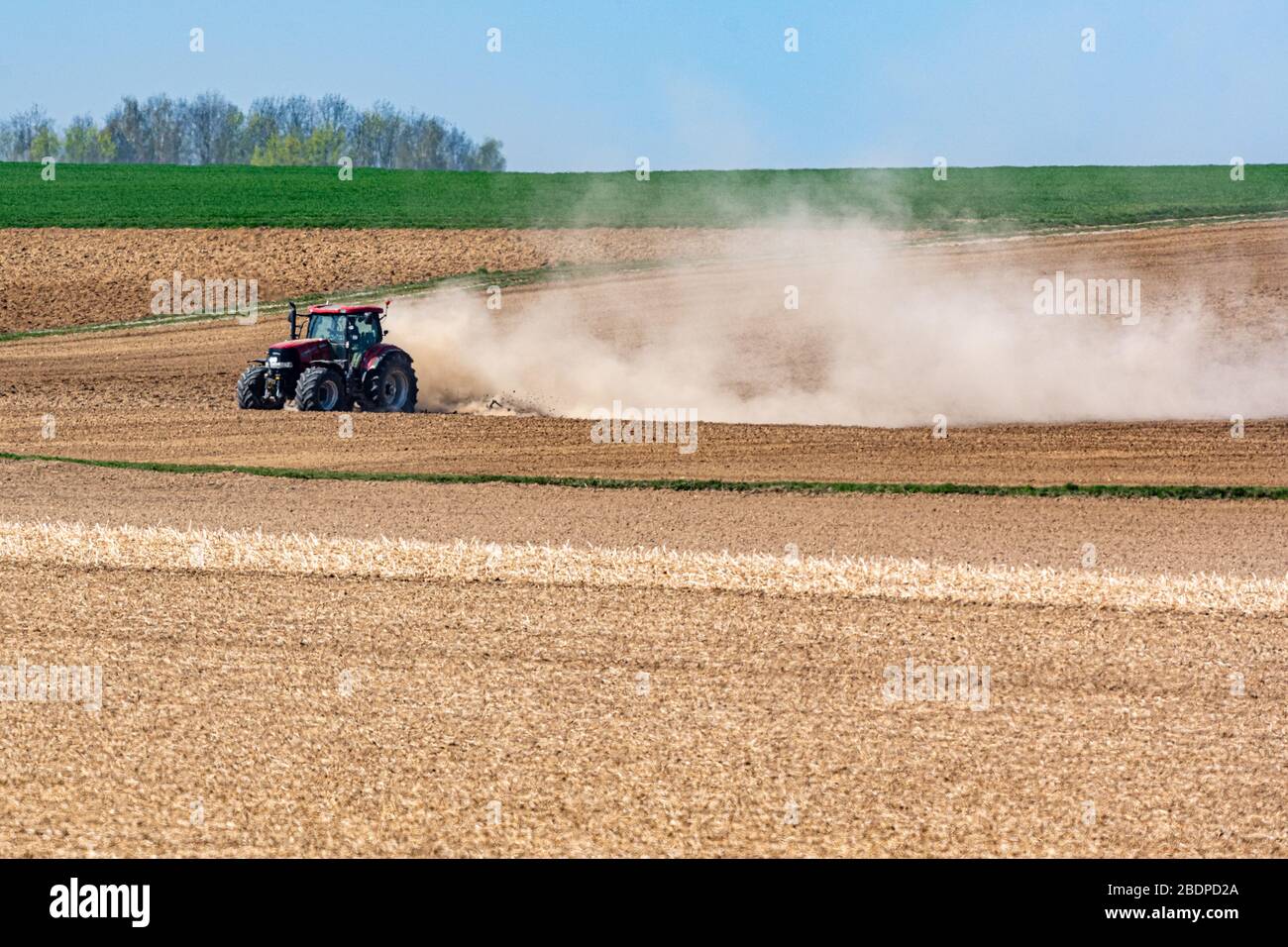 Sand, Germany. 09th Apr, 2020. A farmer kicks up dust with his tractor ...