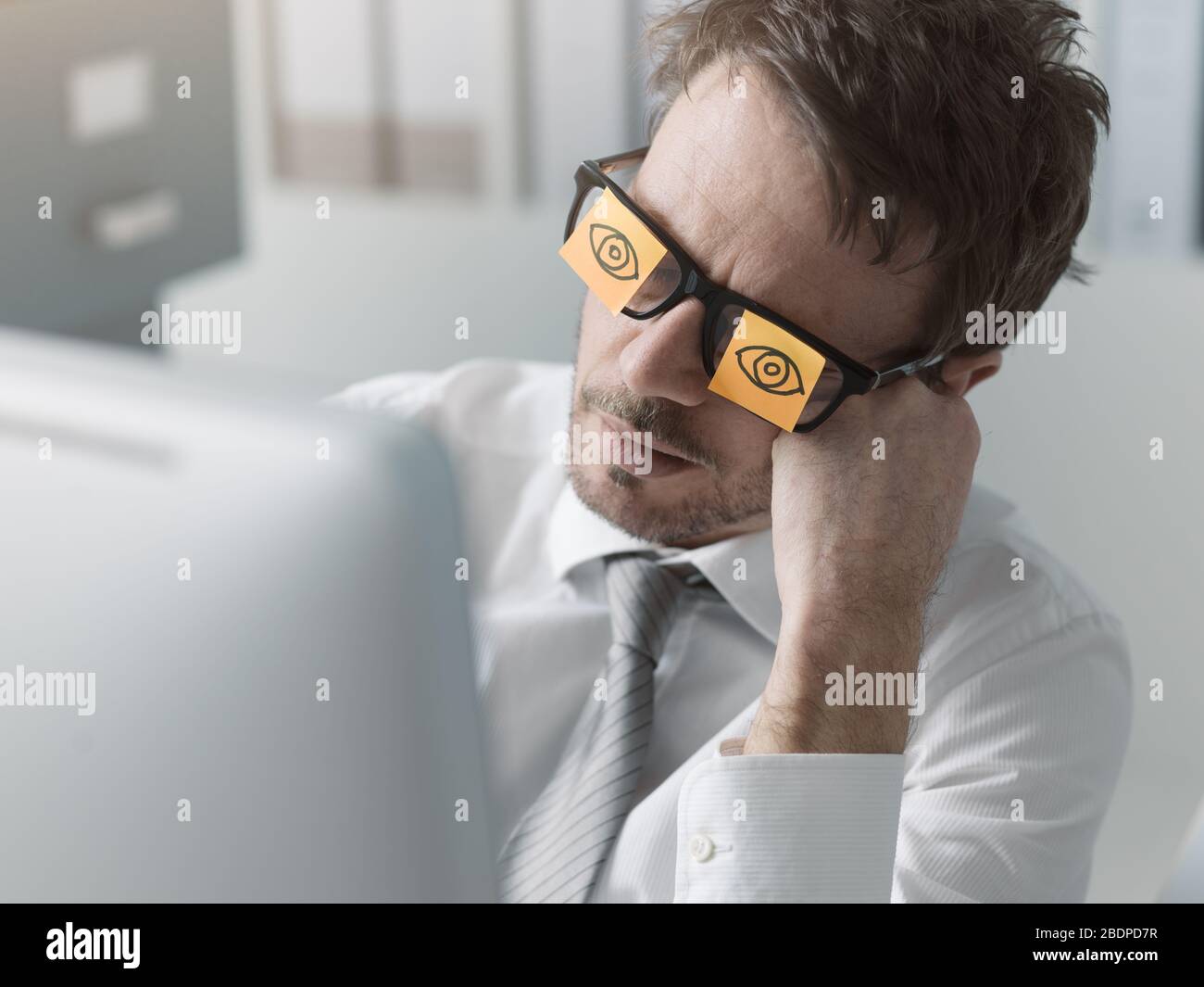 Lazy unproductive office worker wearing funny sticky notes on his ...