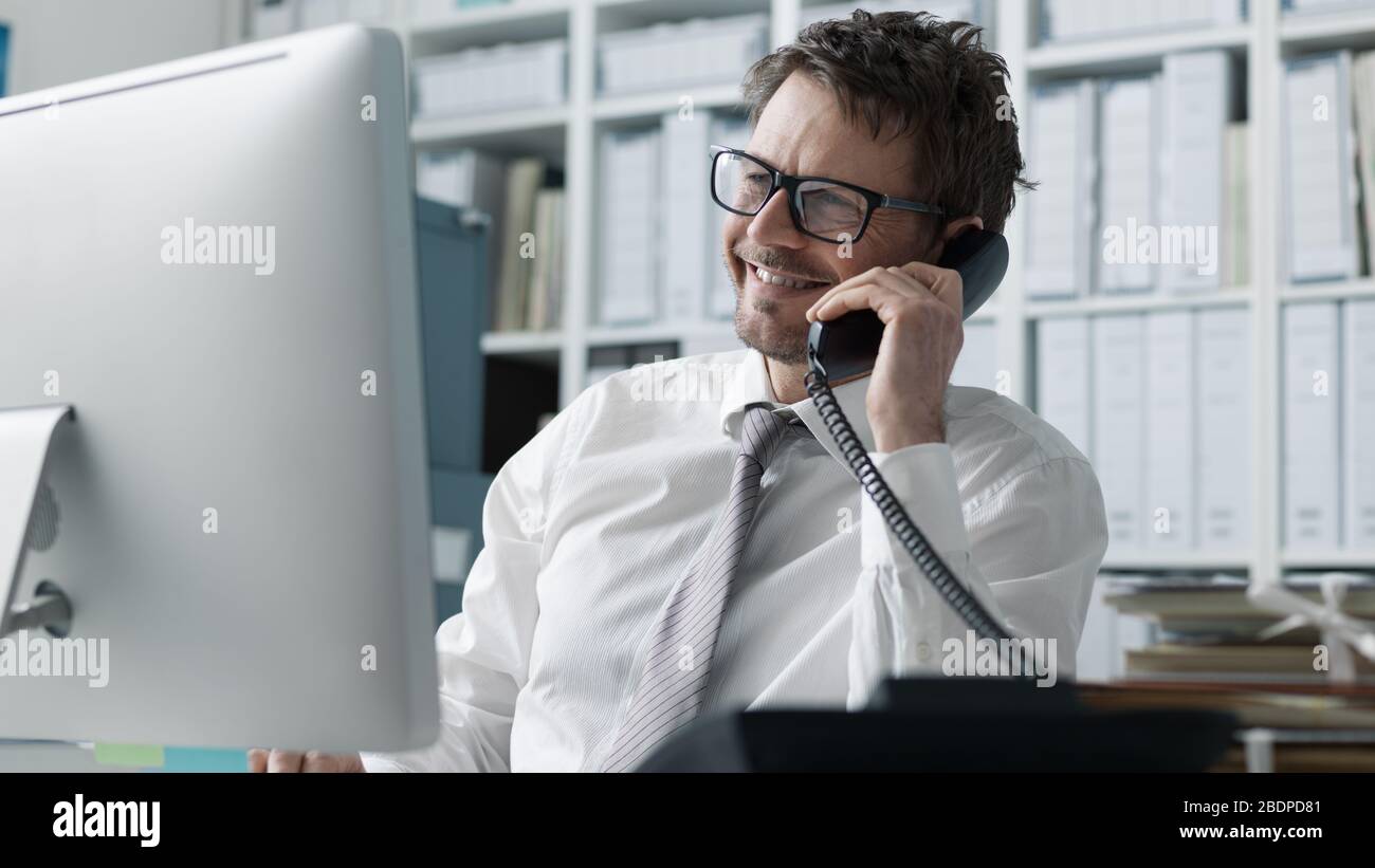 Smiling confident business executive having a phone call in the office ...