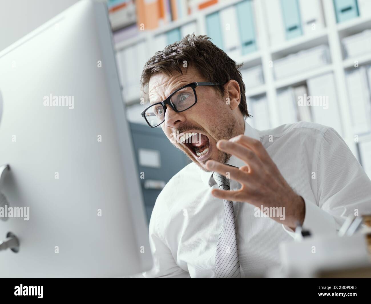 Angry business executive shouting at the computer, stressful job and ...