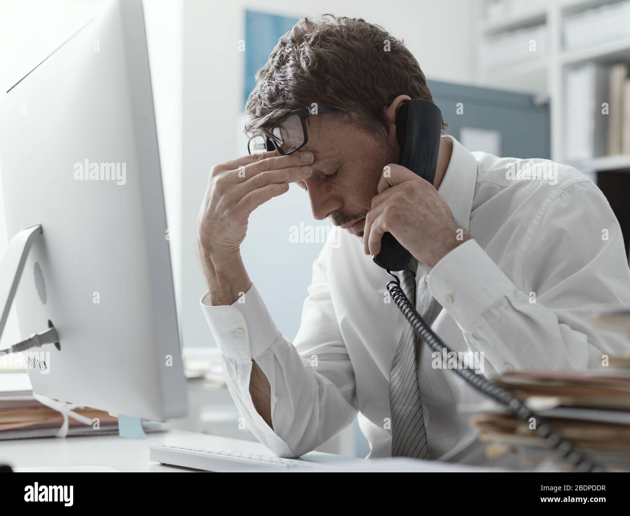 Business executive working in the office and receiving bad news on the ...