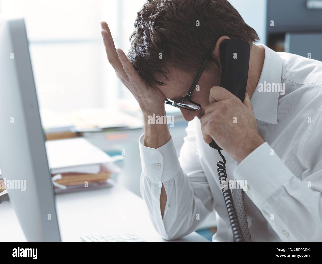 Business executive working in the office and receiving bad news on the ...