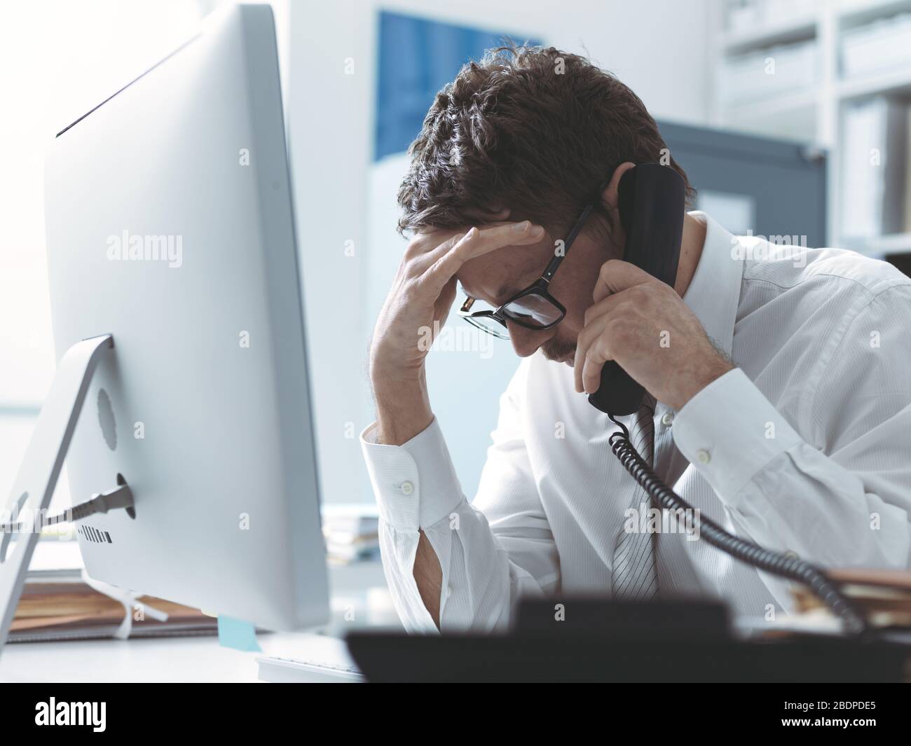 Business executive working in the office and receiving bad news on the ...