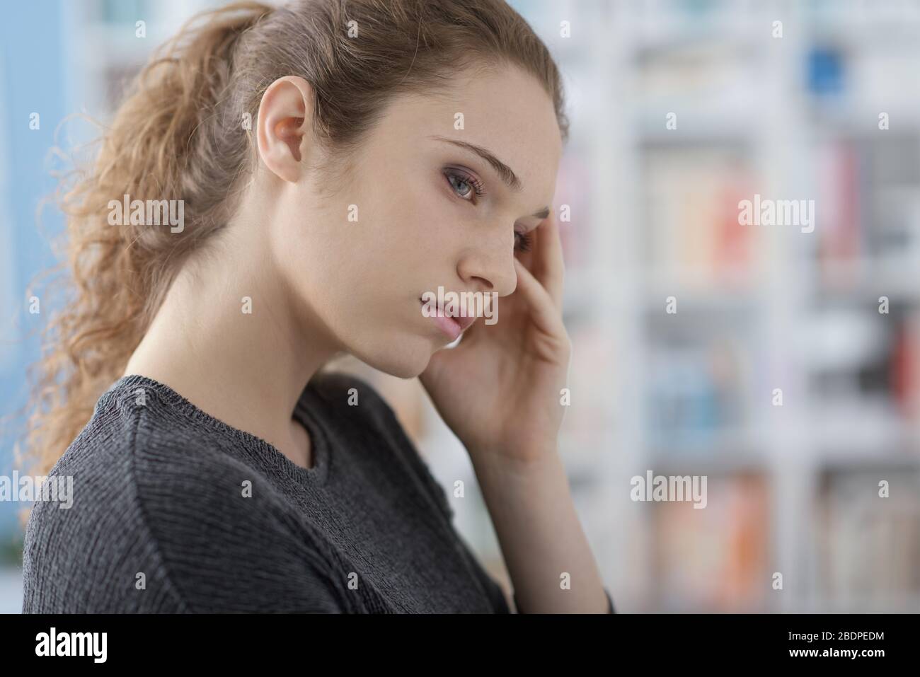 Young woman touching her temples and having a bad headache, stress and ...