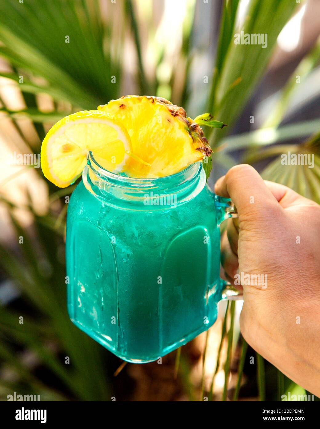 blue cocktail with pineapple slice Stock Photo - Alamy