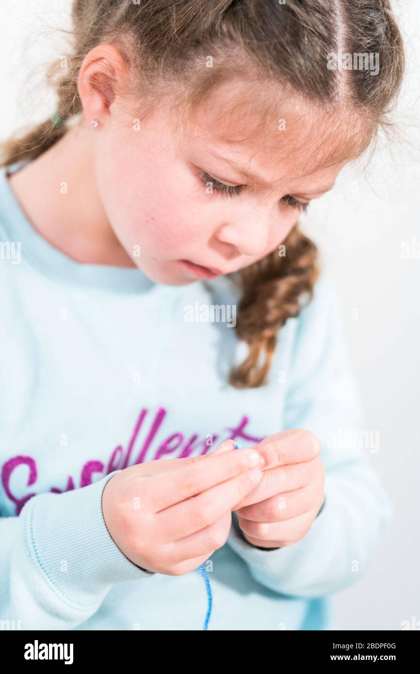 Little girl learning how to sew with sewing craft kit for kids Stock ...