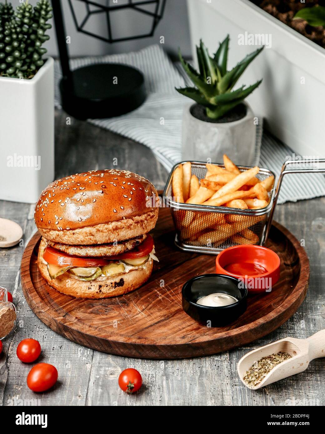 burger with fries on wooden desk Stock Photo - Alamy