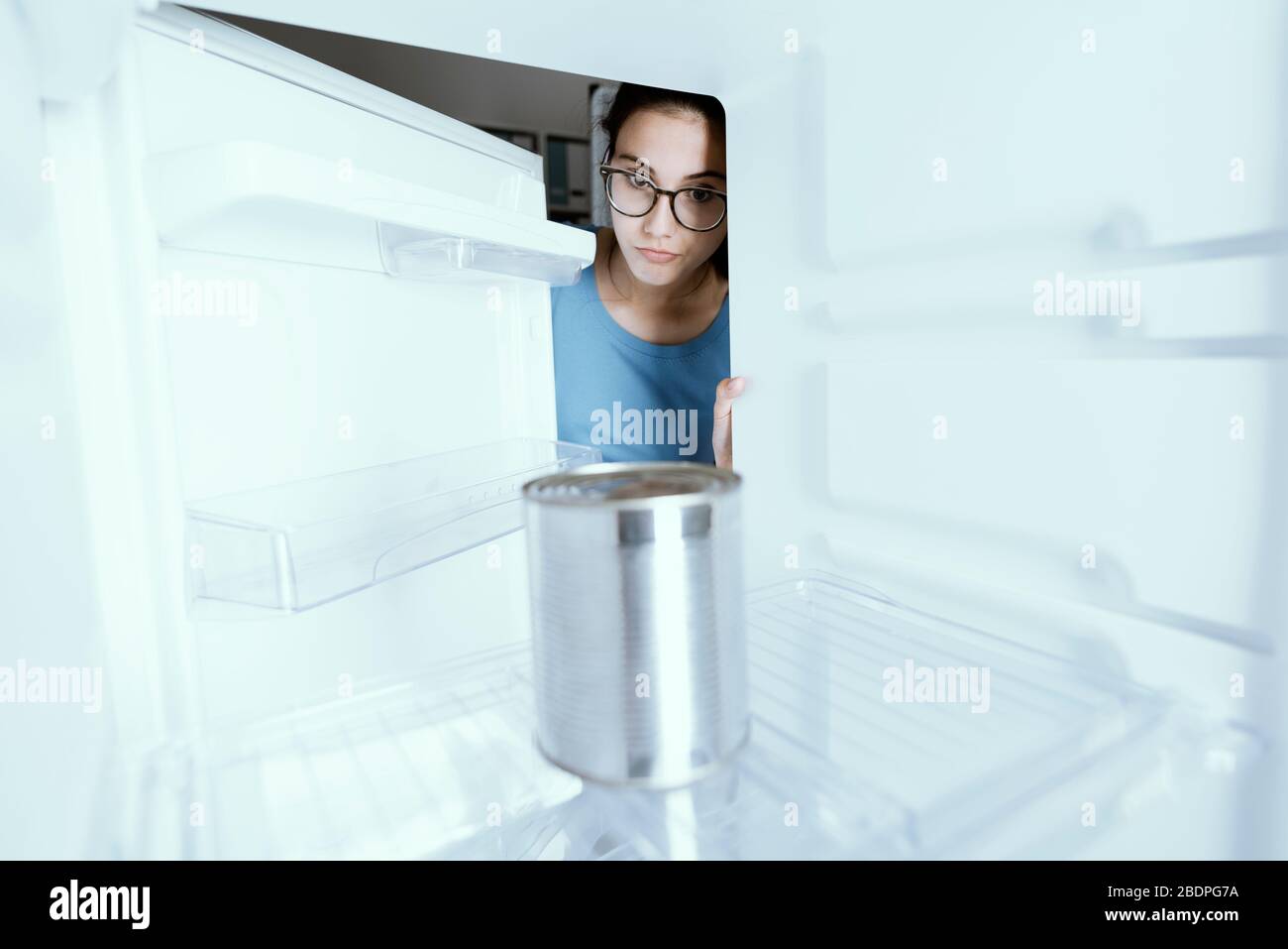 Sad woman looking into her empty fridge with no groceries Stock Photo ...