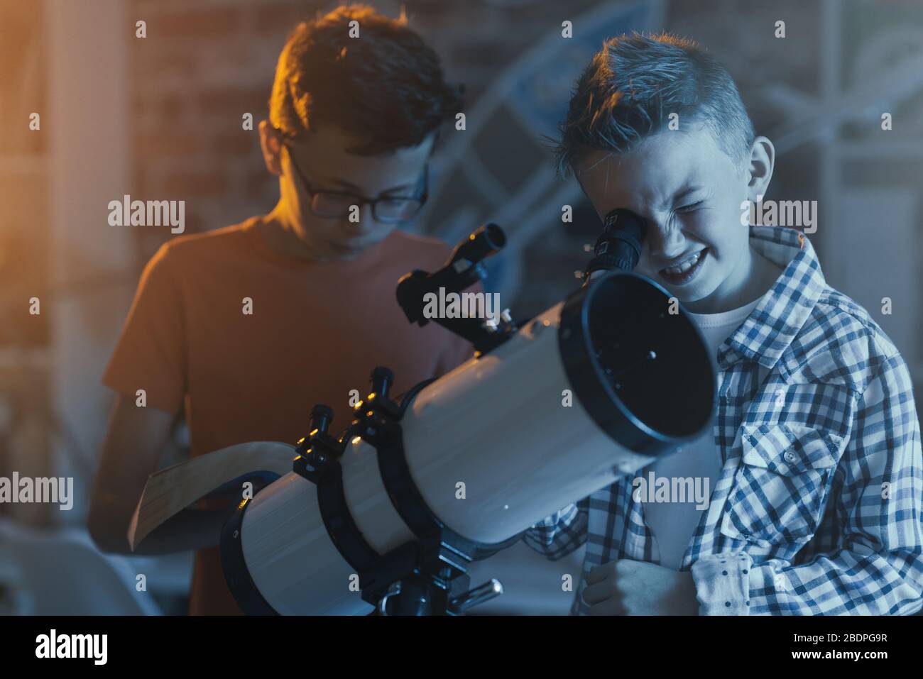 Smart kids using a telescope and studying astronomy together, they are ...