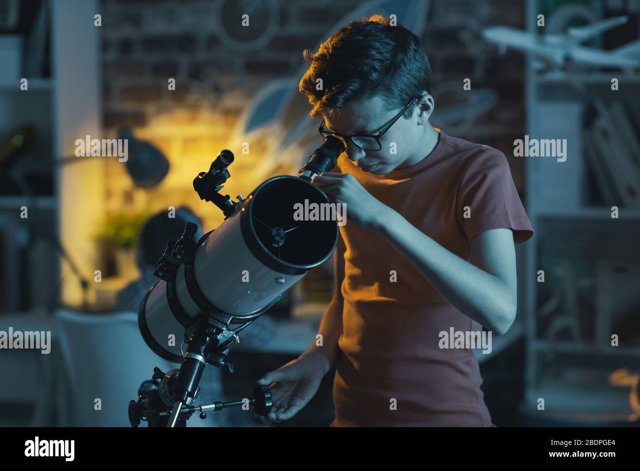 Smart nerd guy with glasses watching stars with a telescope in his ...