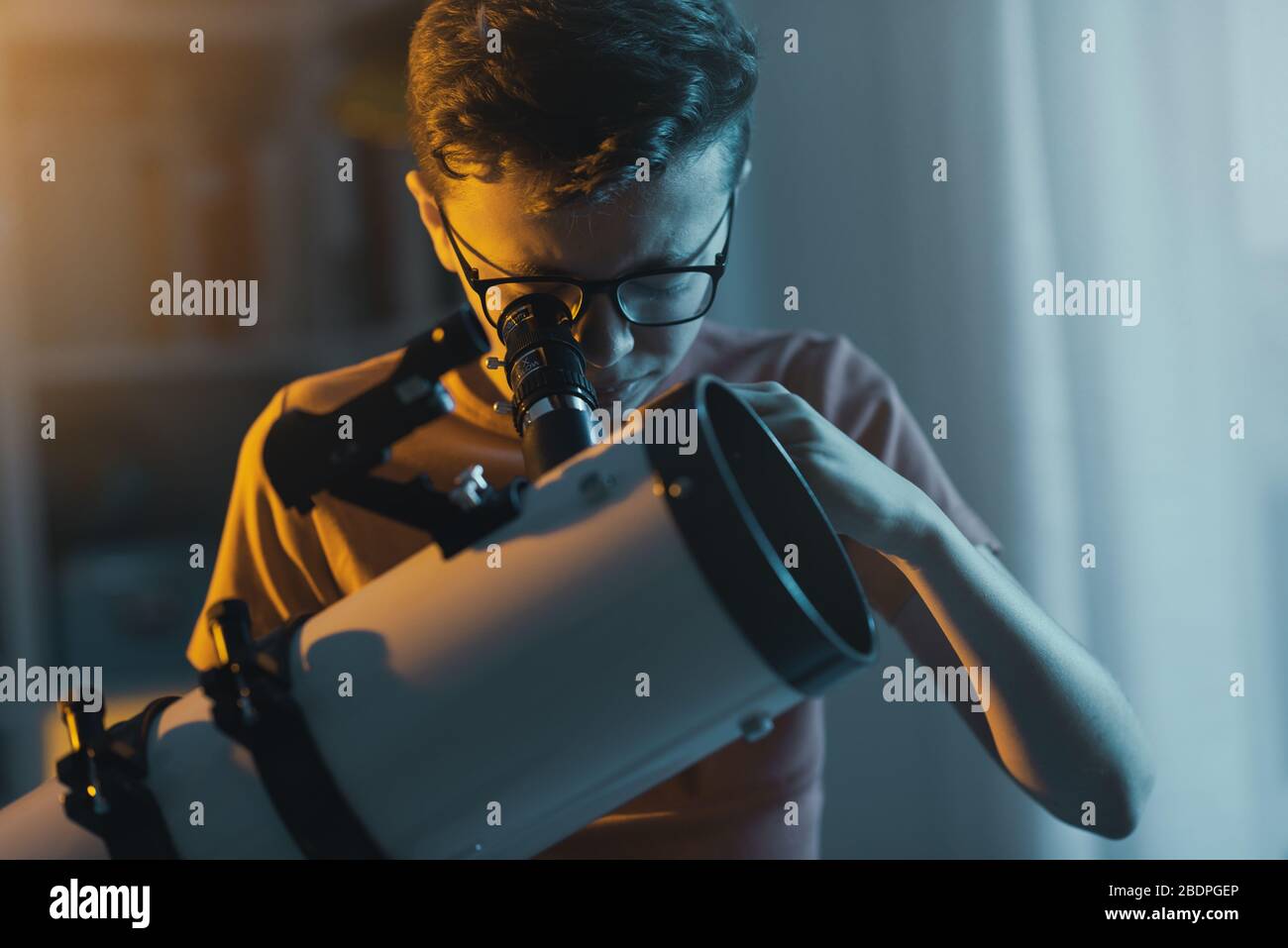 Smart nerd guy with glasses watching stars with a telescope in his ...