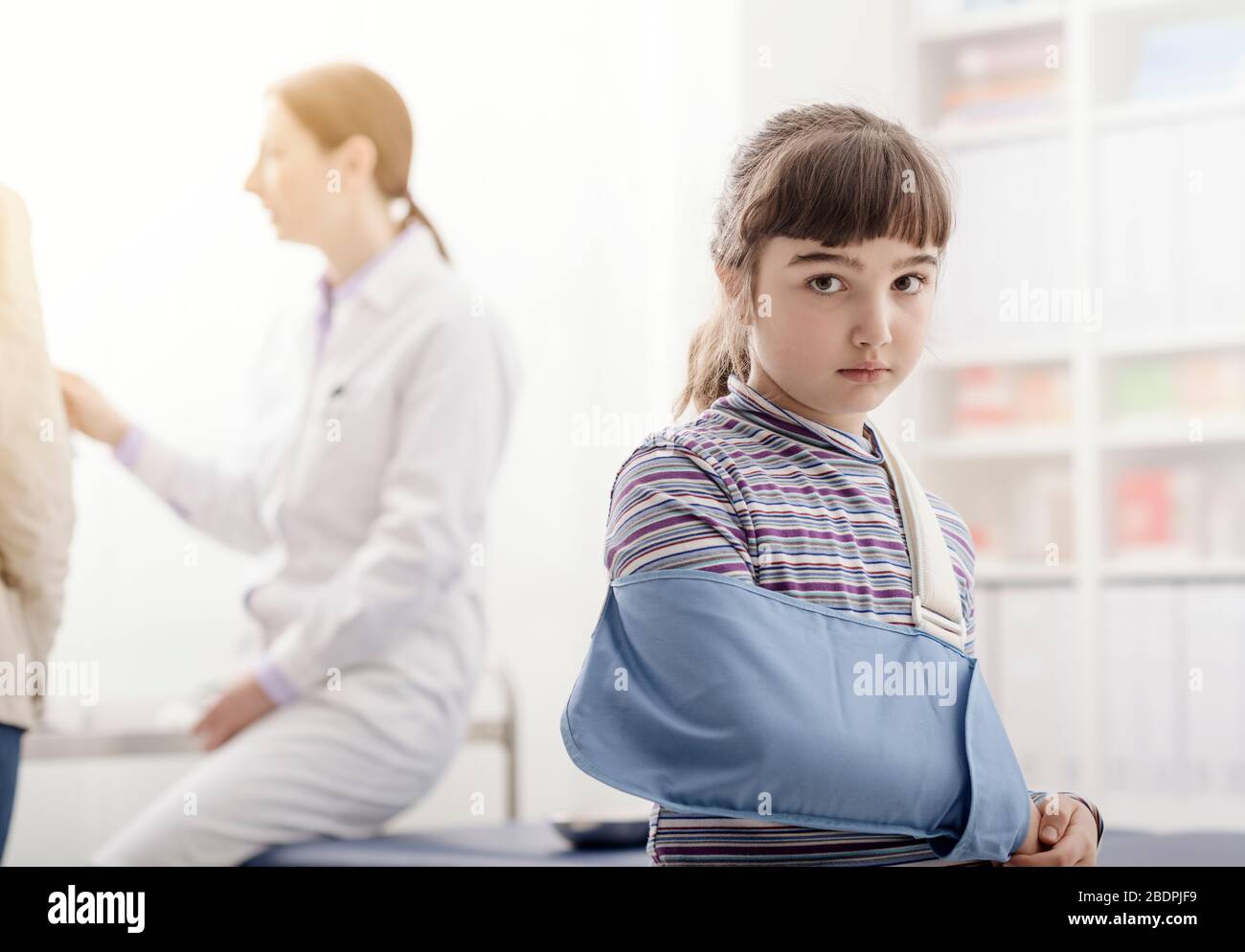 Girl with broken arm in the doctor's office, she is wearing an arm ...