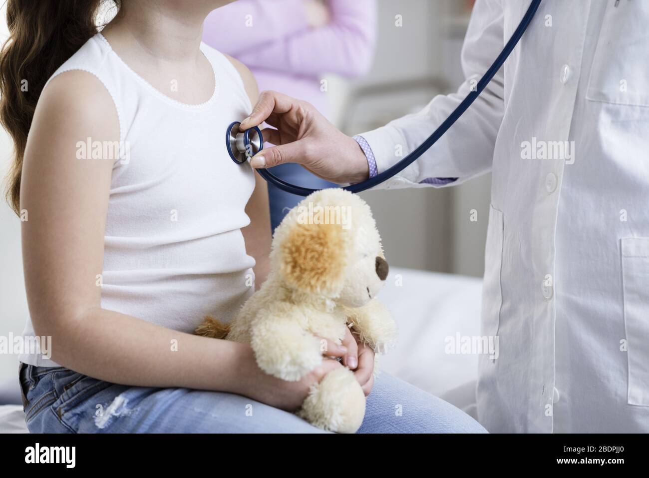 Doctor checking a girl's heartbeat with a stethoscope, kids and ...