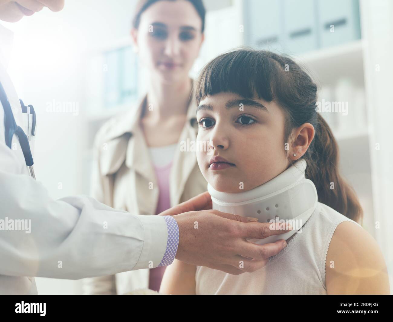 Doctor visiting a young girl with orthopedic cervical collar, first aid ...