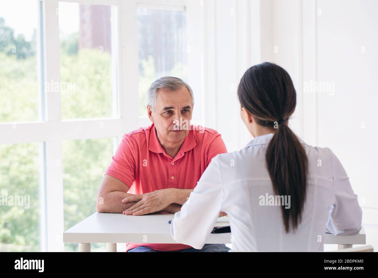 Senior patient listen to young woman doctor in a hospital Stock Photo ...