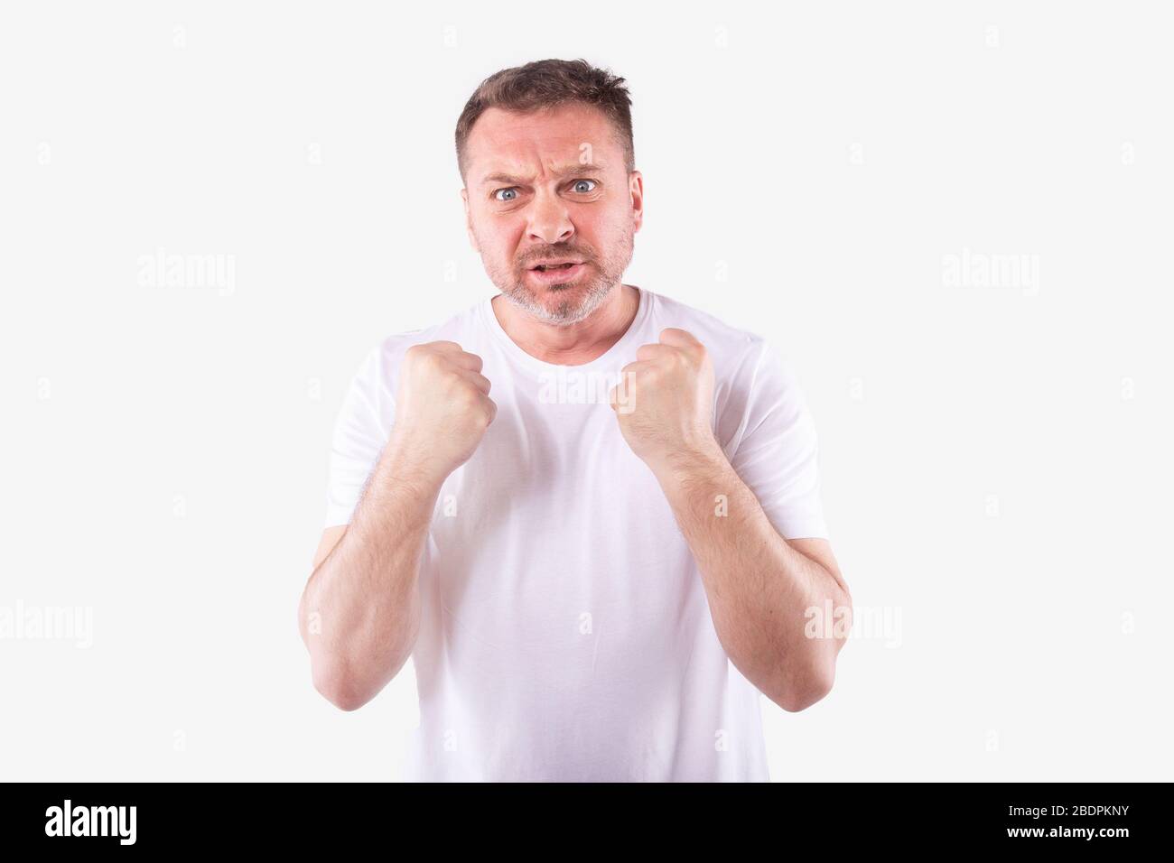 Angry man, hands clenched into fists, teeth clenched. Isolated, white ...
