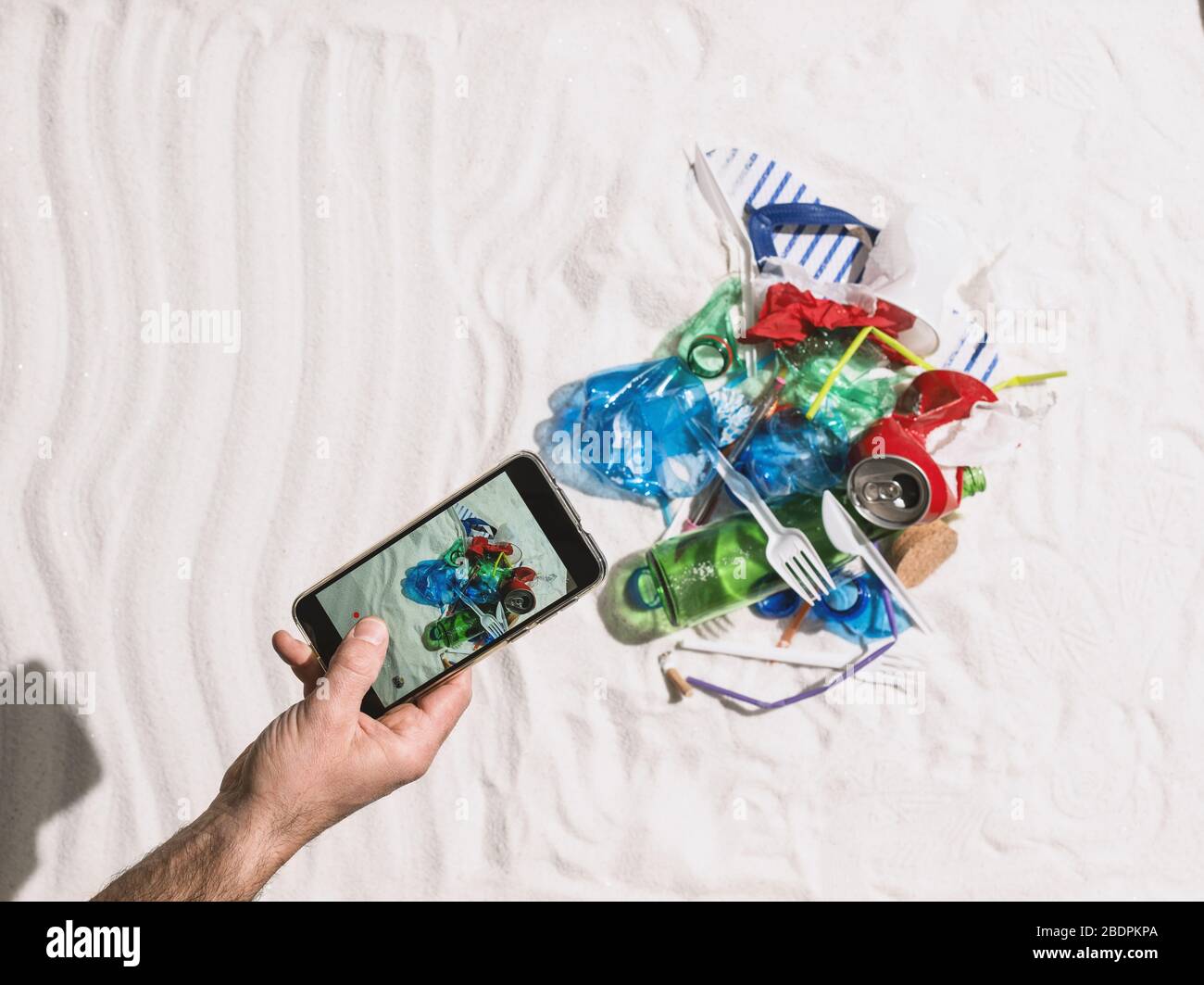Man taking a picture of waste pollution on the beach and sharing it ...