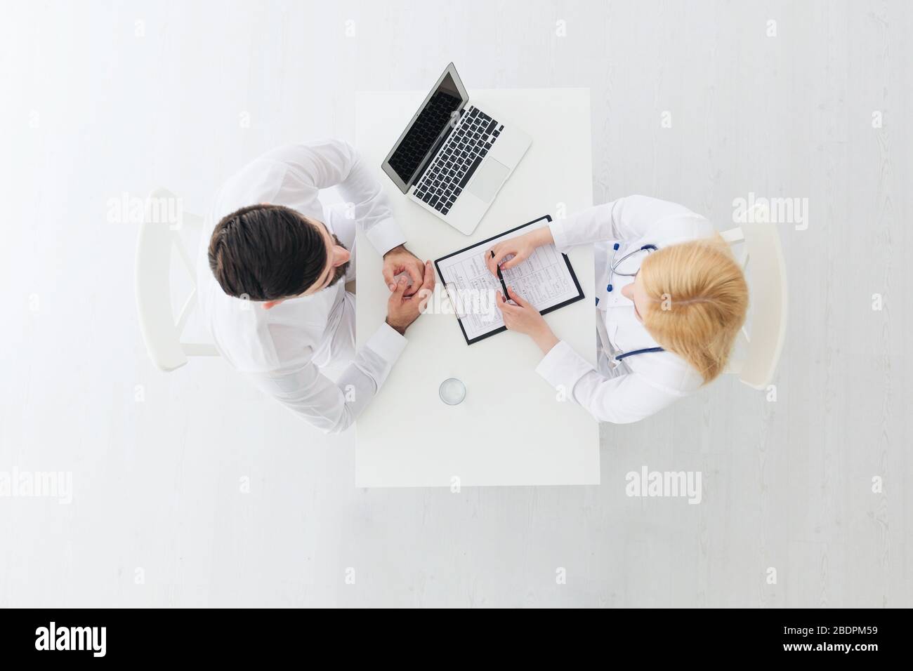 Female doctor consults patient. Top view Stock Photo - Alamy