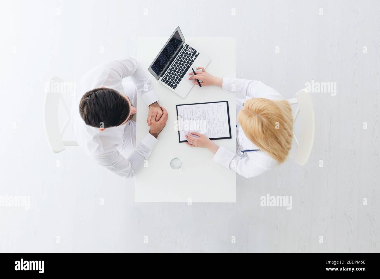 Female doctor consults patient. Top view Stock Photo - Alamy
