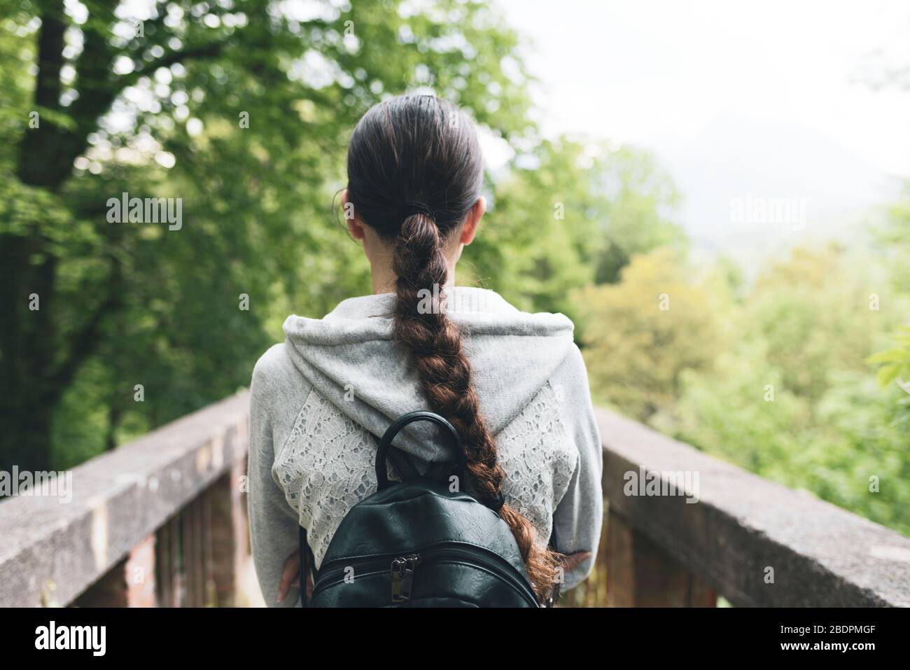Young woman walking in nature and relaxing, she has a beautiful braid ...