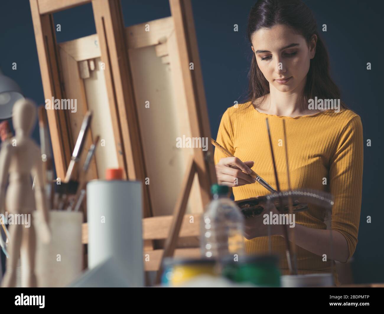 Young creative artist painting in the studio, she is working on an ...