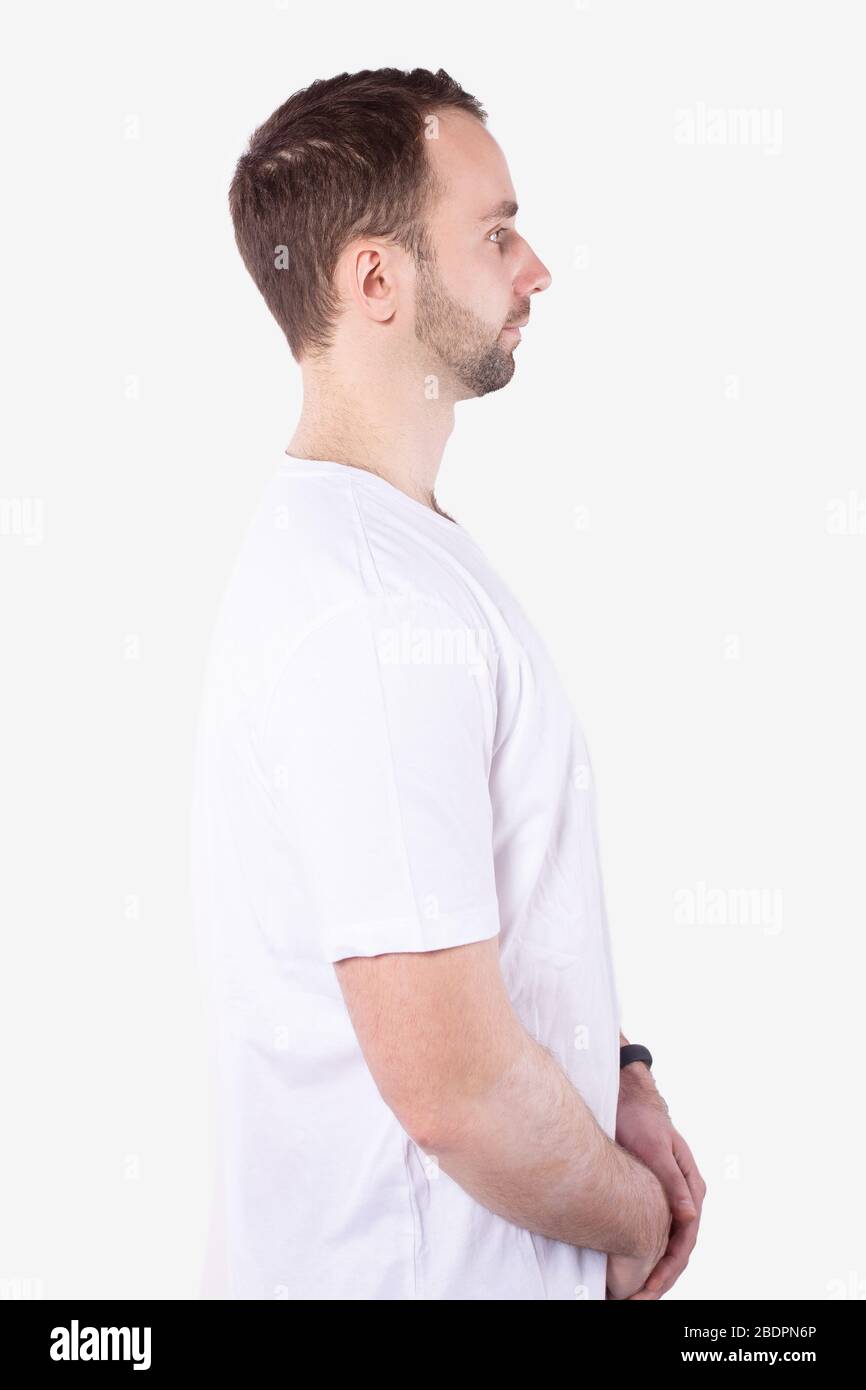 Man stands sideways and looks straight ahead. Arms folded. White ...