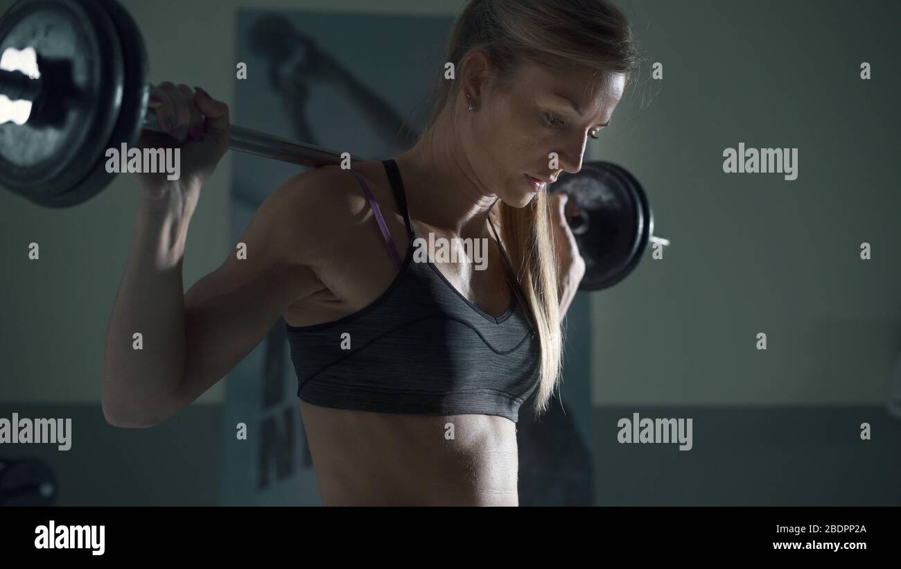 Athletic bodybuilder woman working out at the gym, she is doing ...