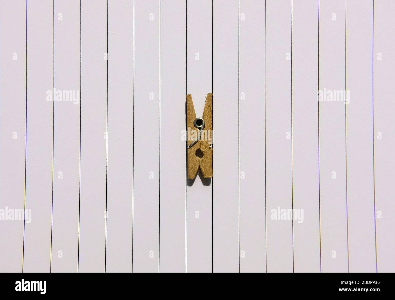 Wooden clothespin on a white lined surface top view Stock Photo - Alamy
