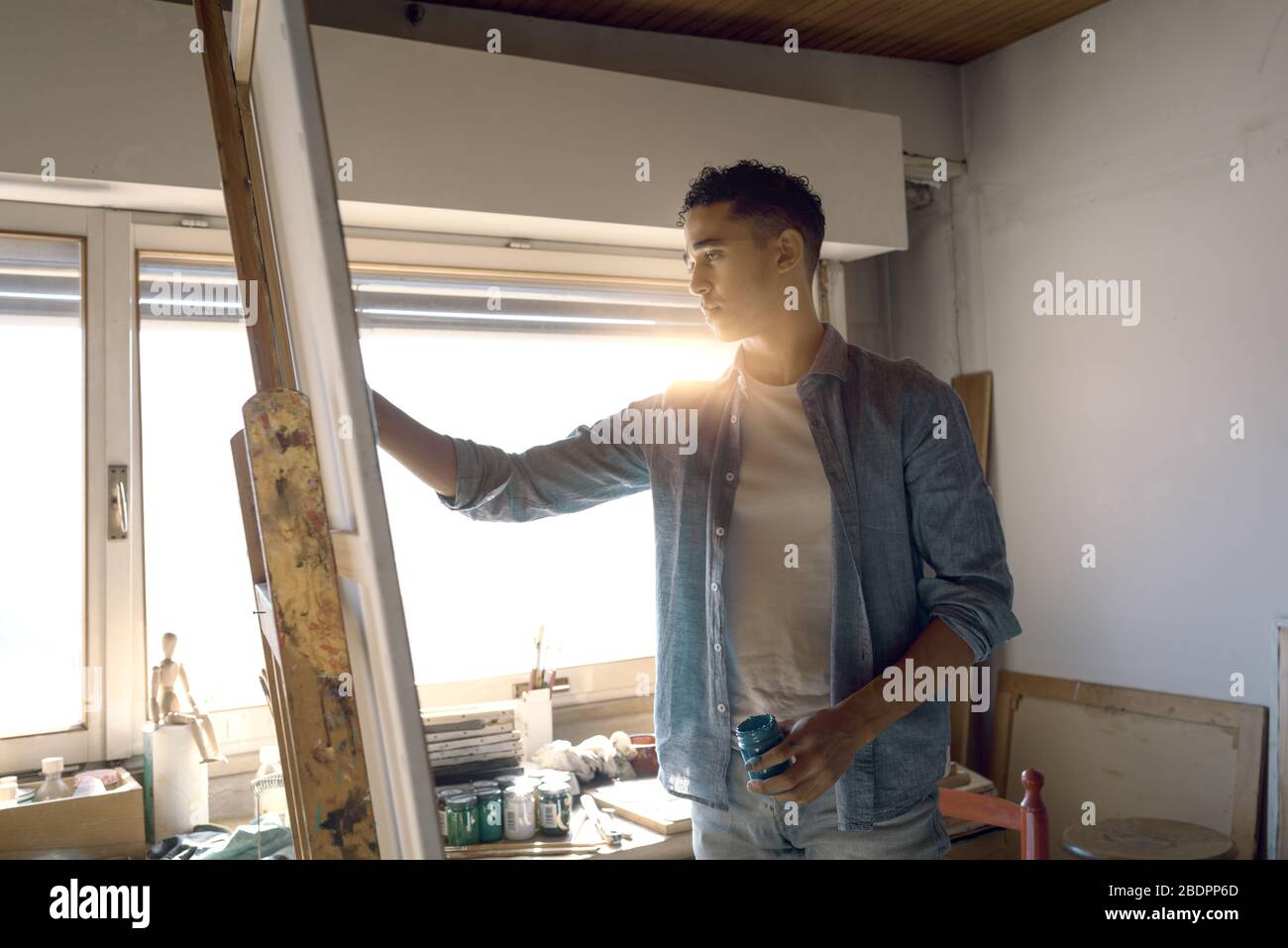 Young creative artist working on his artwork in the studio, he is ...