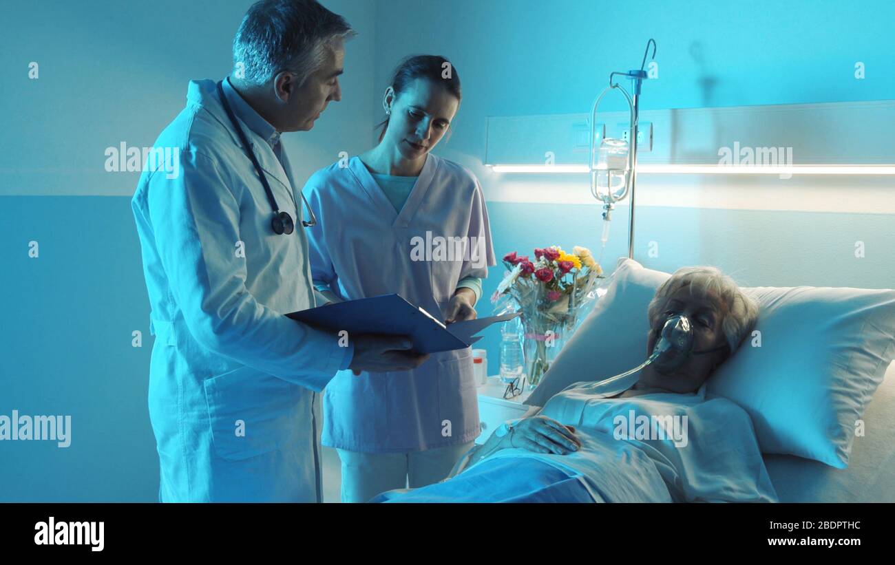 Doctor and nurse next to hospital bed hi-res stock photography and ...