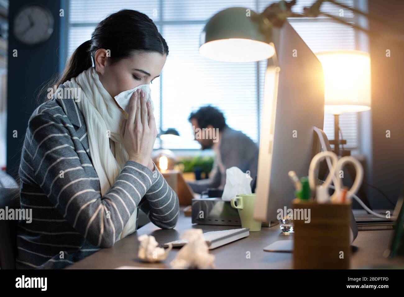 Young office worker sitting at office desk and working, she is having a ...