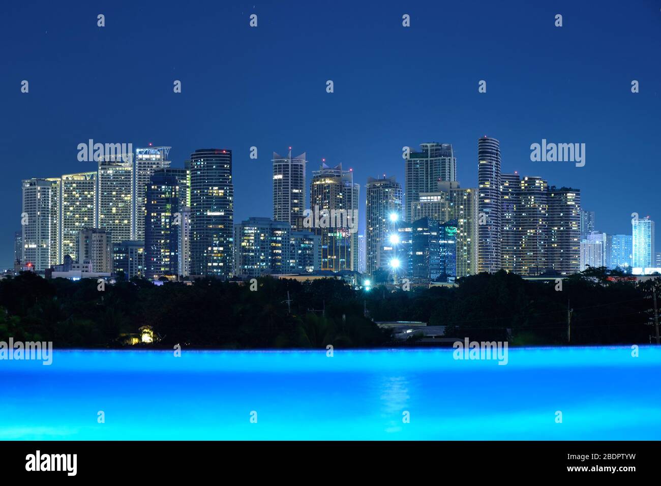 View of the night city of Manila from the pool of the luxury five-star ...