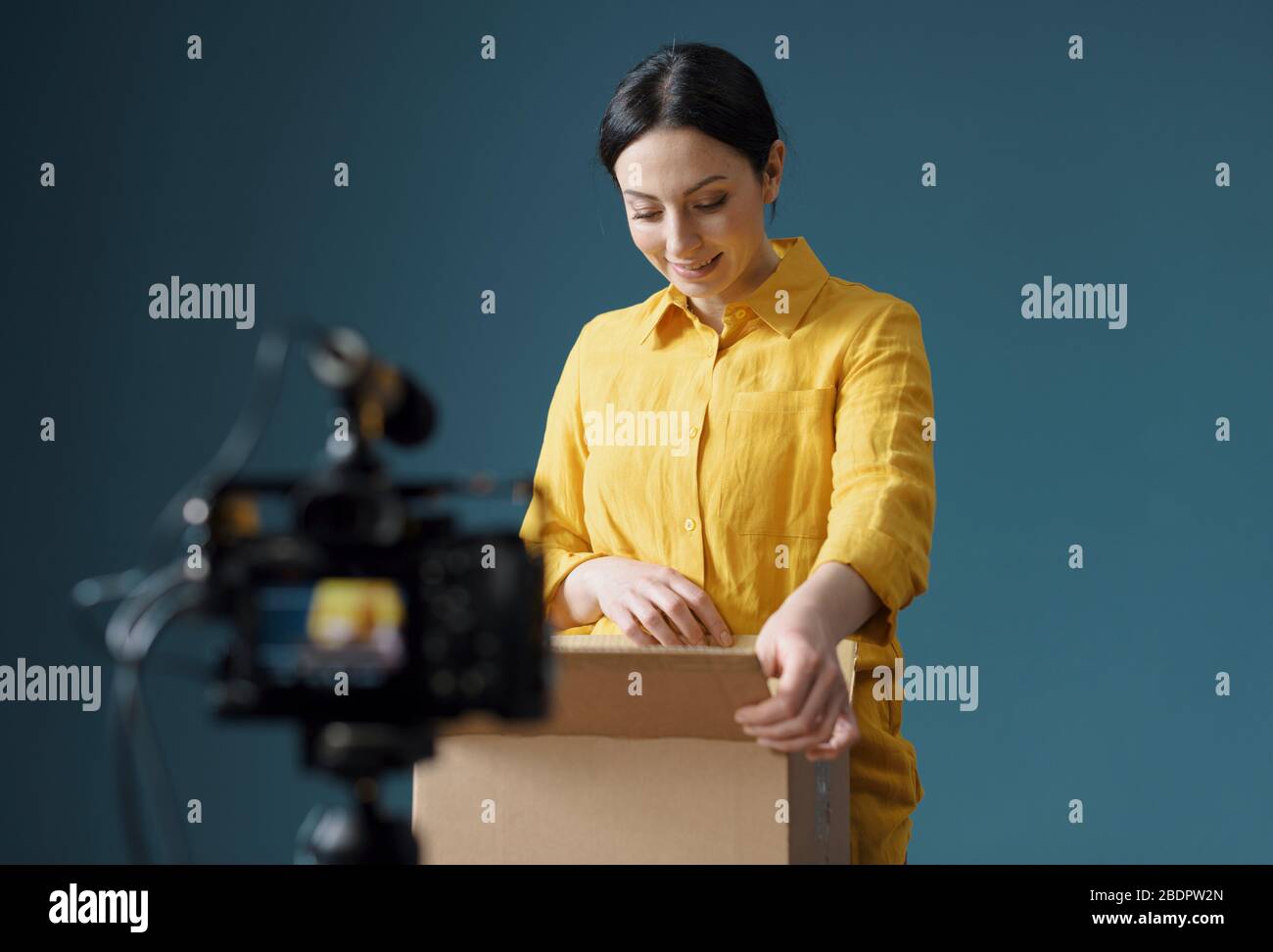 Vlogger making a unboxing video for her channel, she is opening a ...