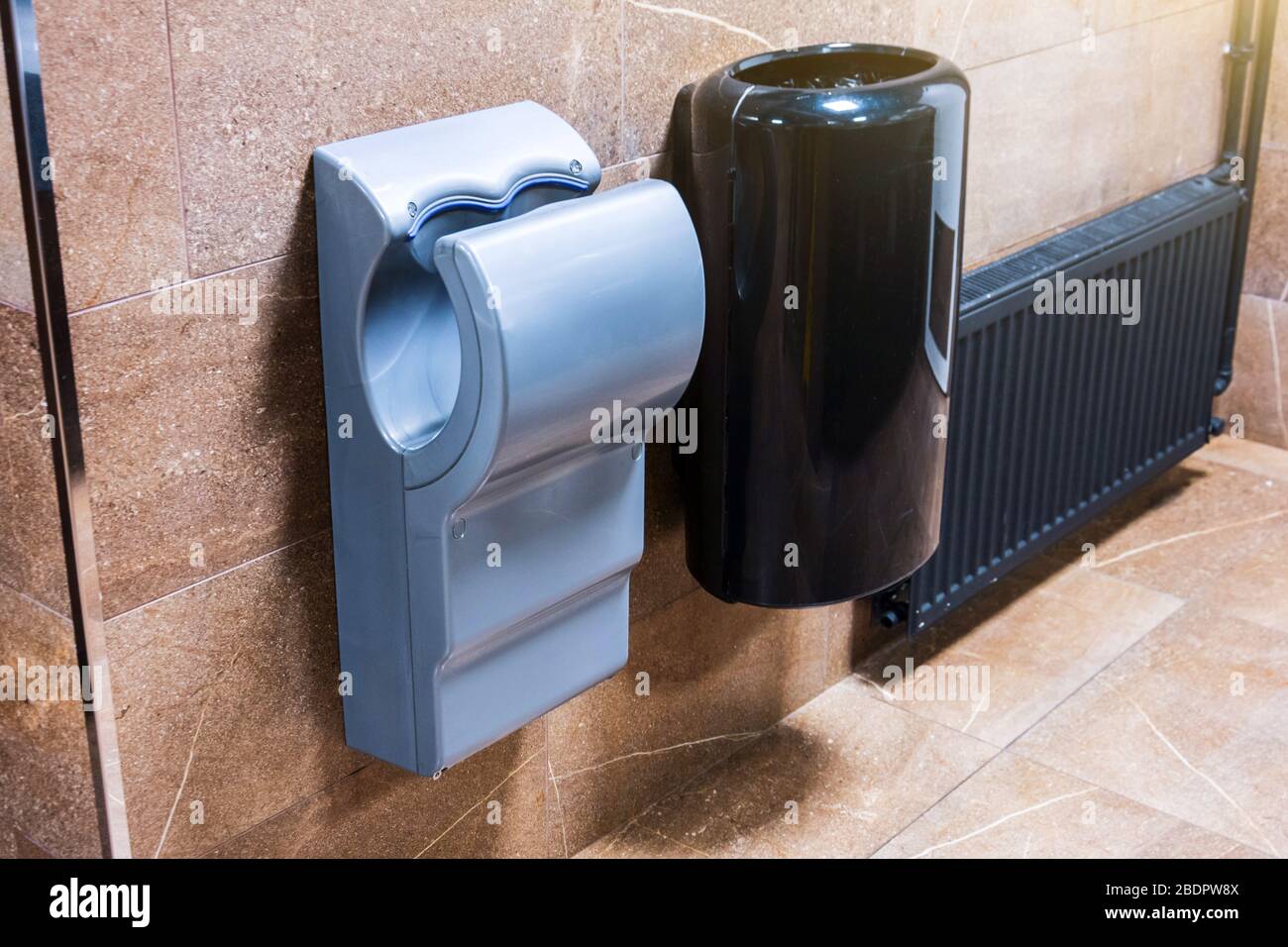 Modern vertical hand dryer and bin for used paper towels in public ...