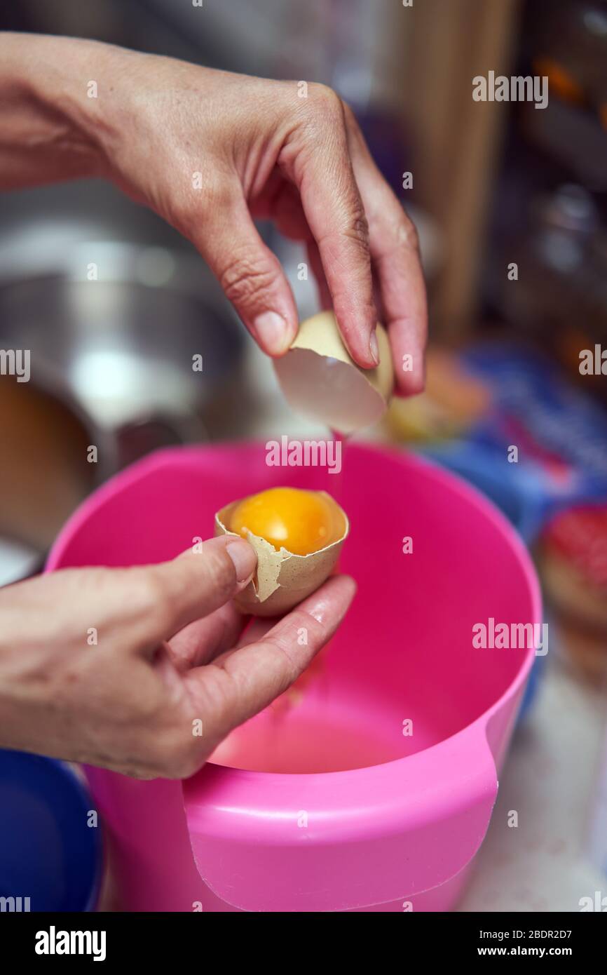 Woman's hands separating egg yolk from whites Stock Photo - Alamy