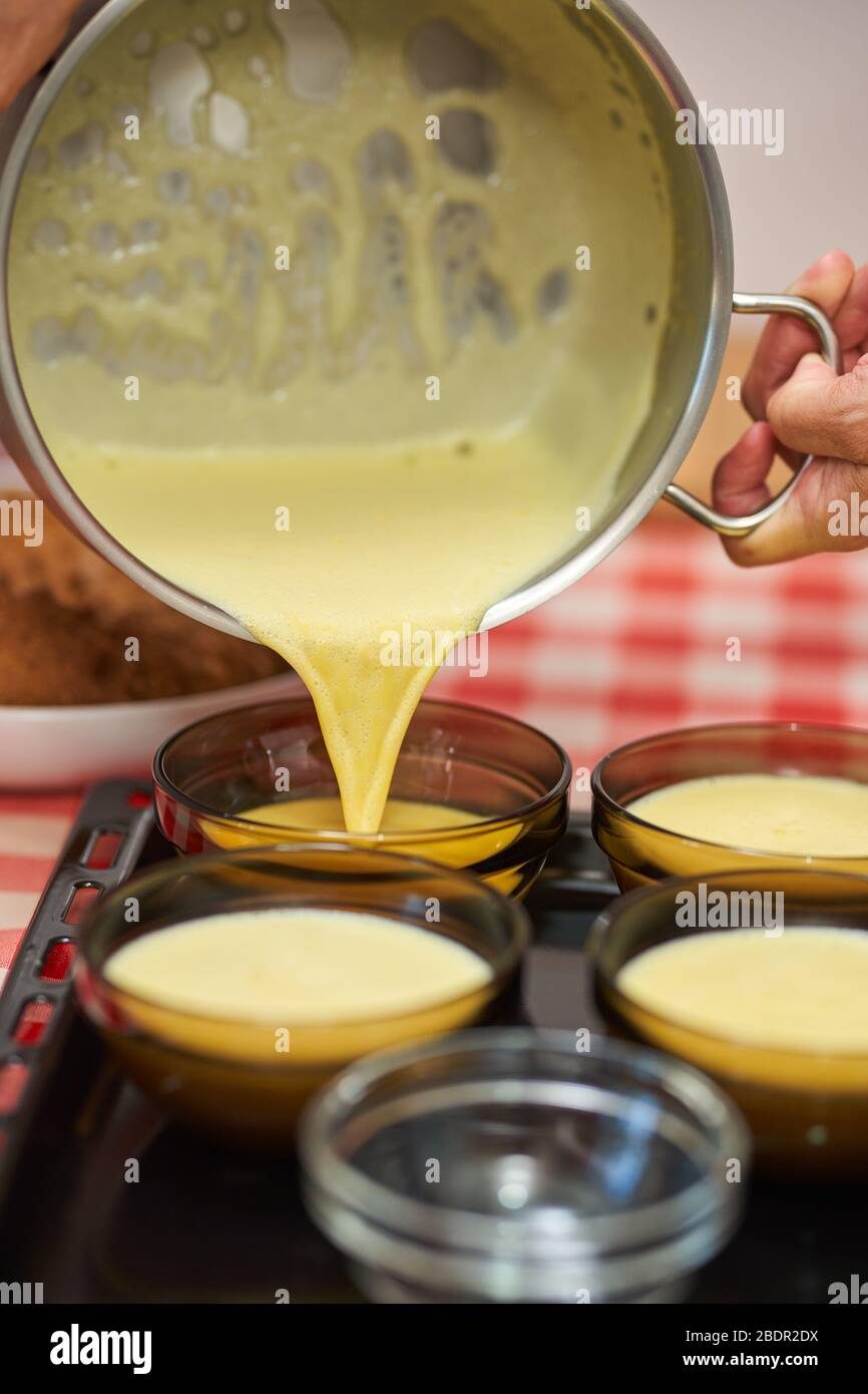 Pouring creme brulee cream into small bowls Stock Photo - Alamy