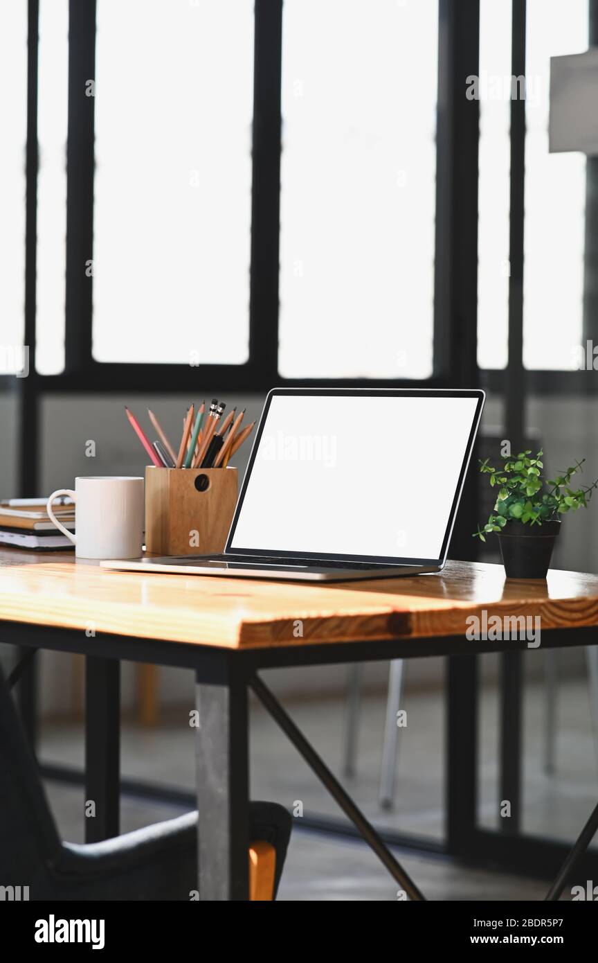 Computer laptop putting on wooden working desk with pencil holder ...
