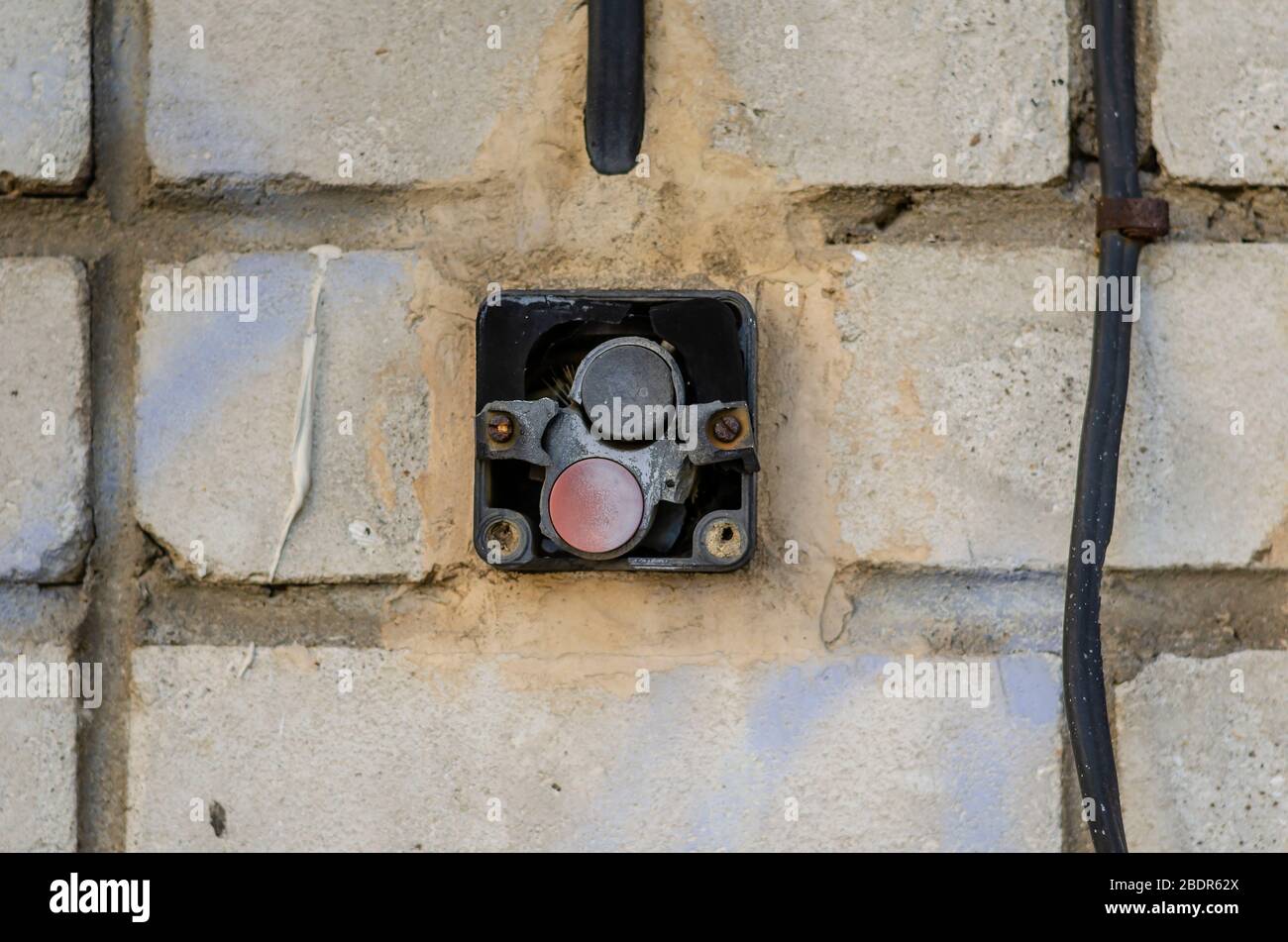 Burnt electric switch on the wall. Worn out batch switch on a brick ...