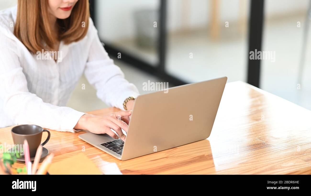 Cropped image of beautiful woman working as secretary typing on ...
