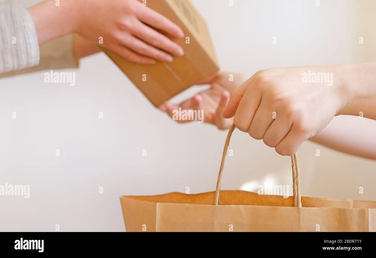 Woman receiving a package at home from a delivery man. Copy space ...