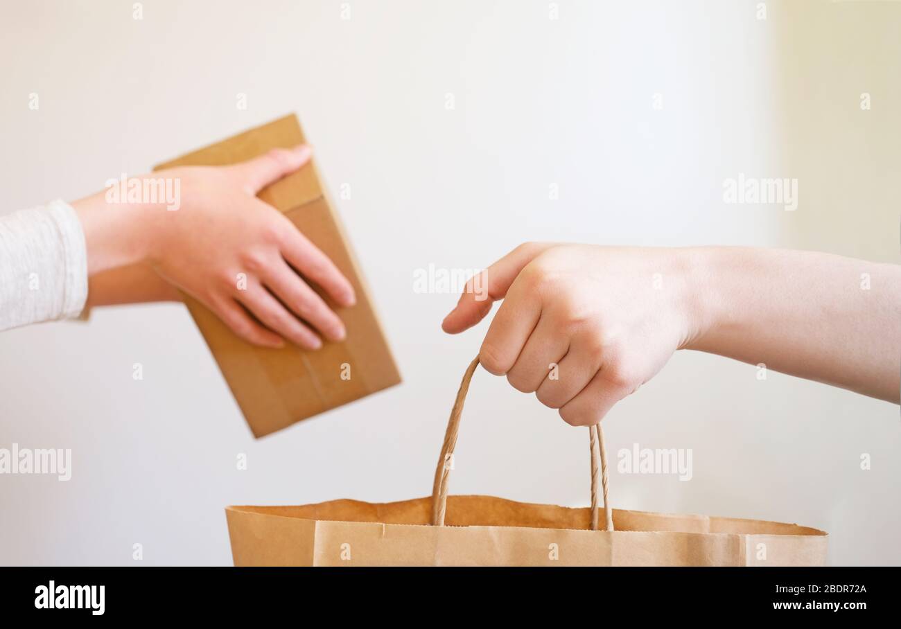 Woman receiving a package at home from a delivery man. Copy space ...